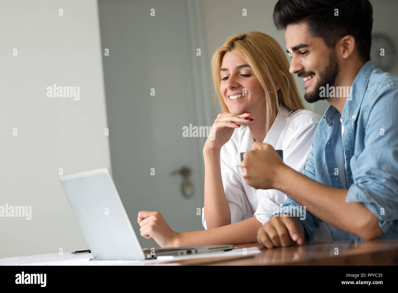 Portrait of a cheerful young couple calculating their bills Stock Photo ...