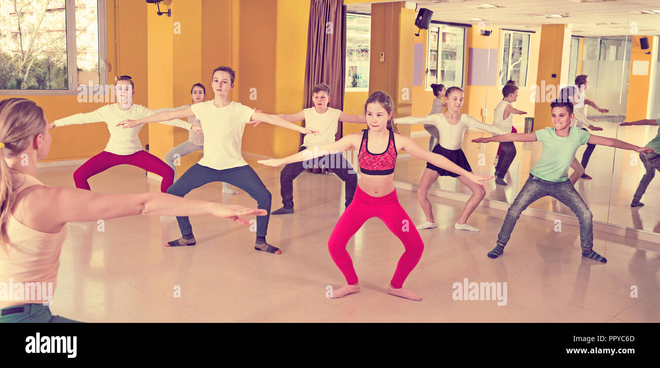 Children dancing synchronous group choreography with female coach at ...