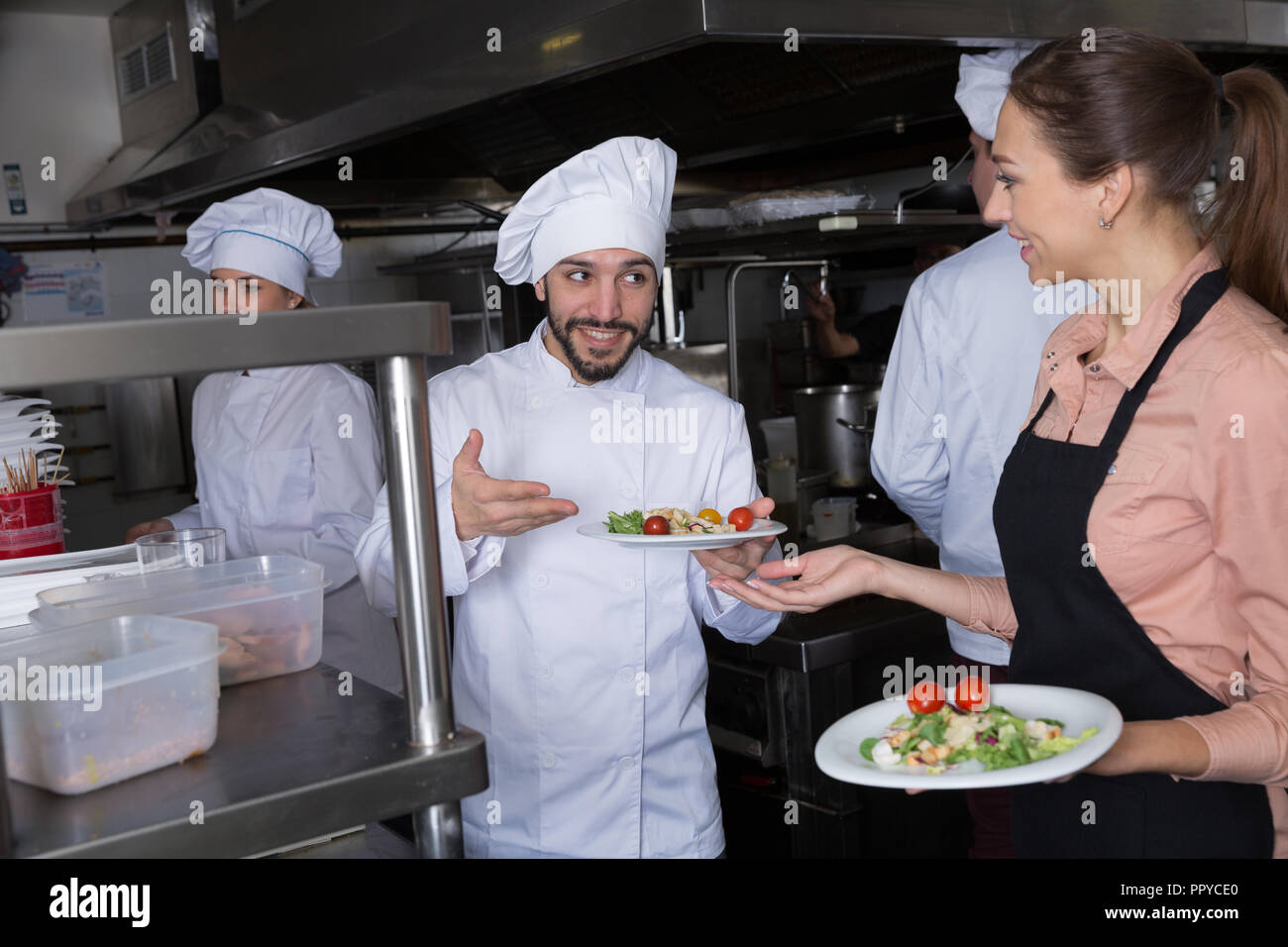 Staff of restaurant with head chef working together in kitchen Stock ...
