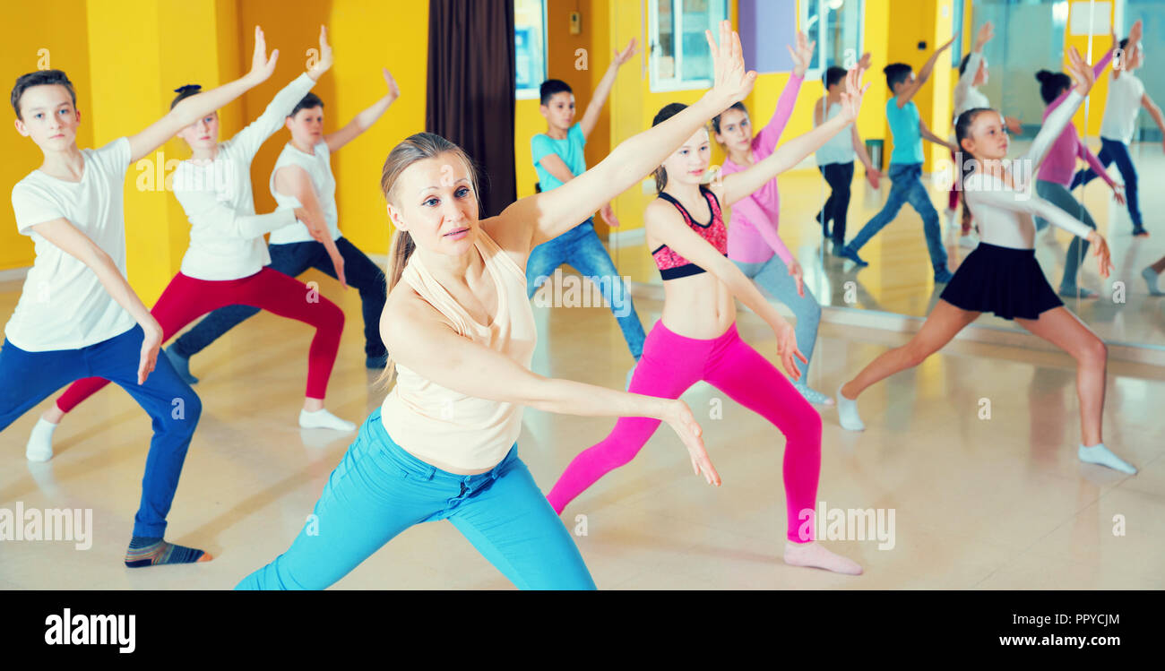 Group of children participating in dance class, following their teacher ...