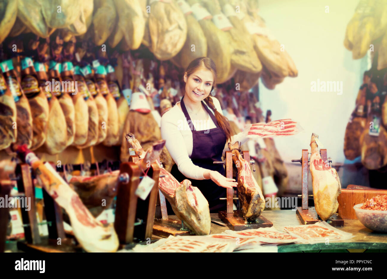 happy american female butcher with lard and meat in counter of store ...