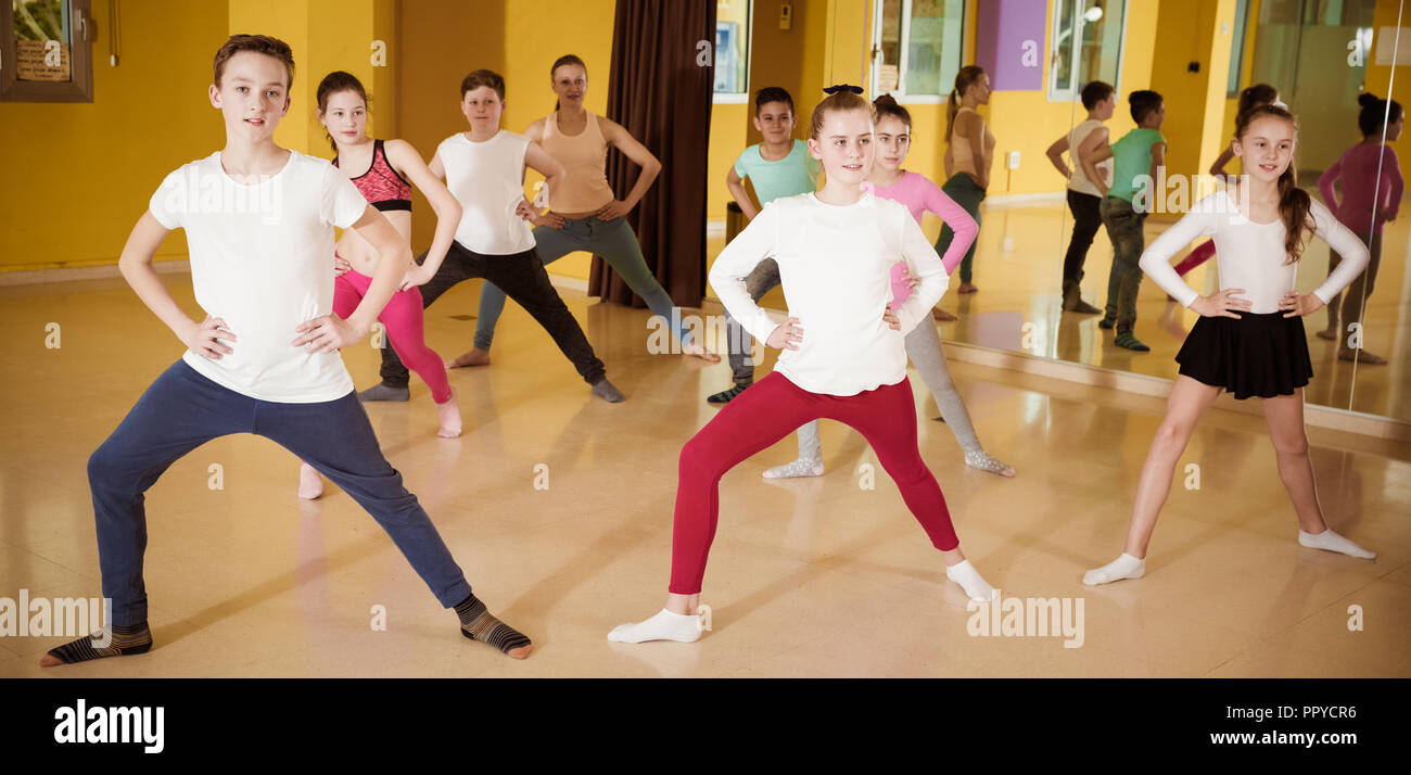 Children dancing synchronous group choreography with female coach in ...