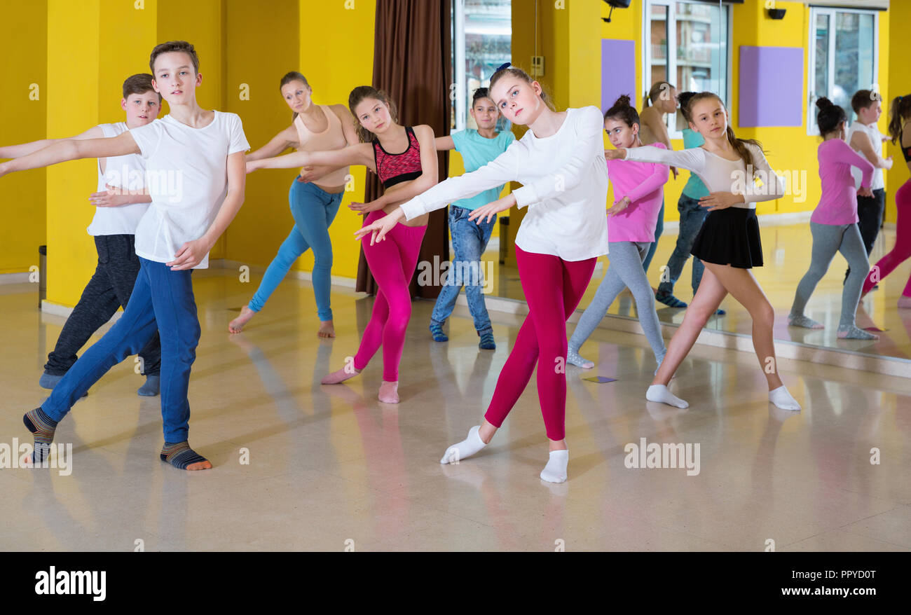 Happy cheerful smiling teenagers dancers practicing dance routine with ...