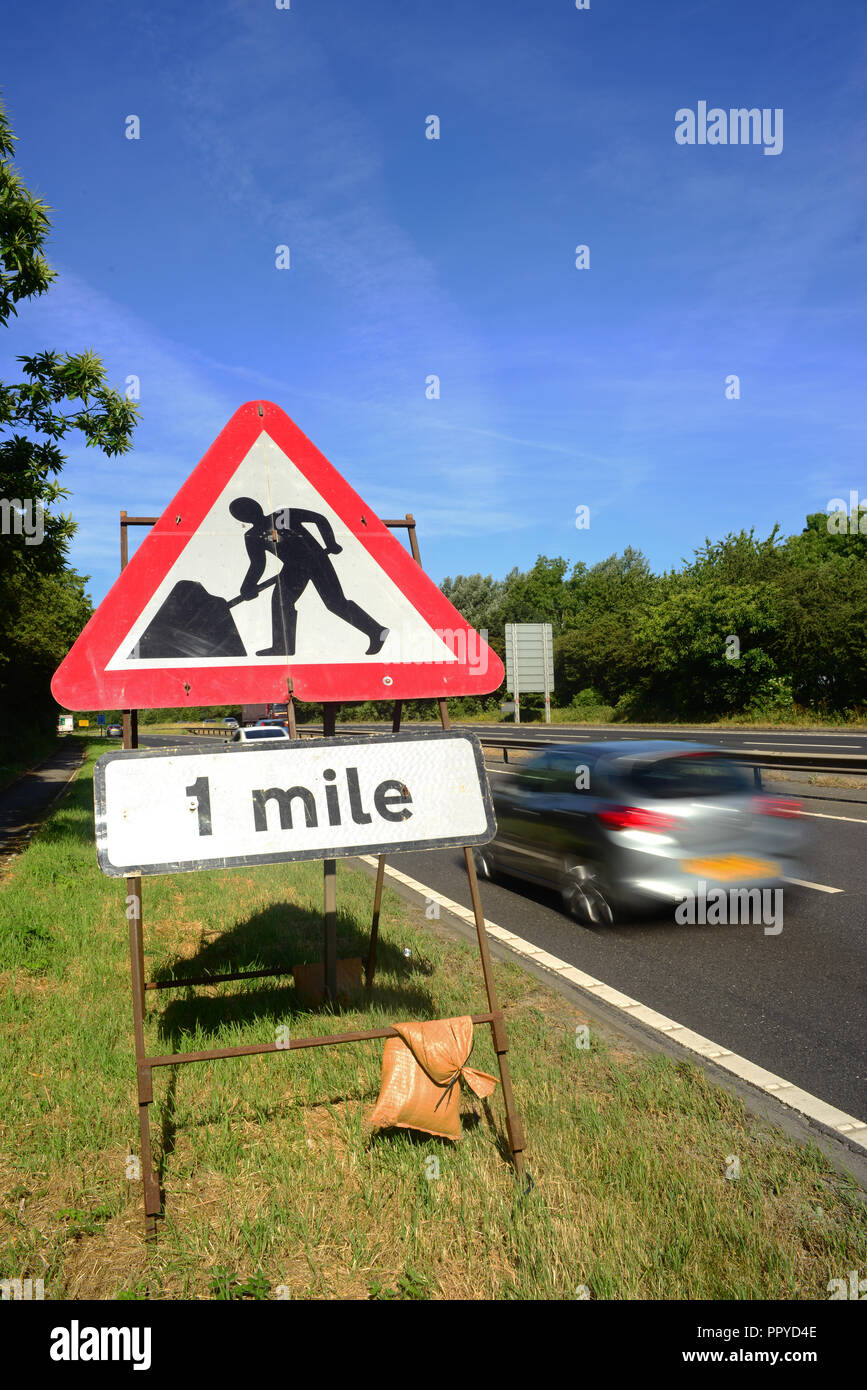 traffic passing roadworks warning sign one mile ahead on the A64 york yorkshire united kingdom ...