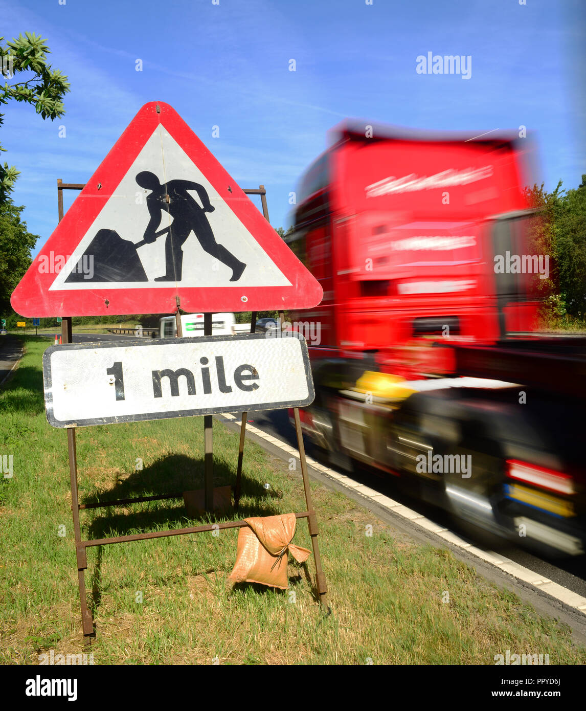traffic passing roadworks warning sign one mile ahead on the A64 york ...