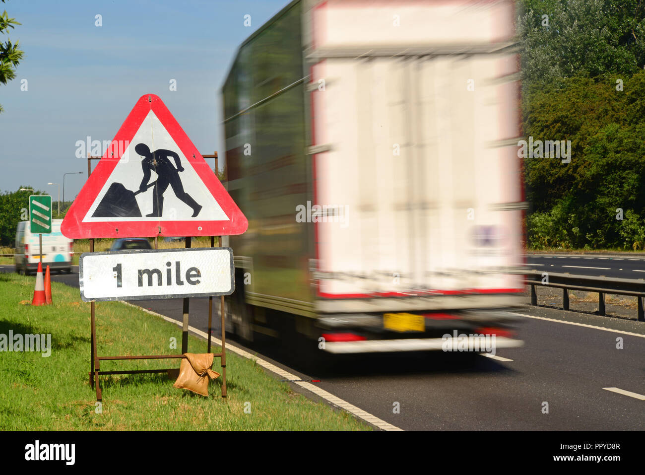 traffic passing roadworks warning sign one mile ahead on the A64 york ...