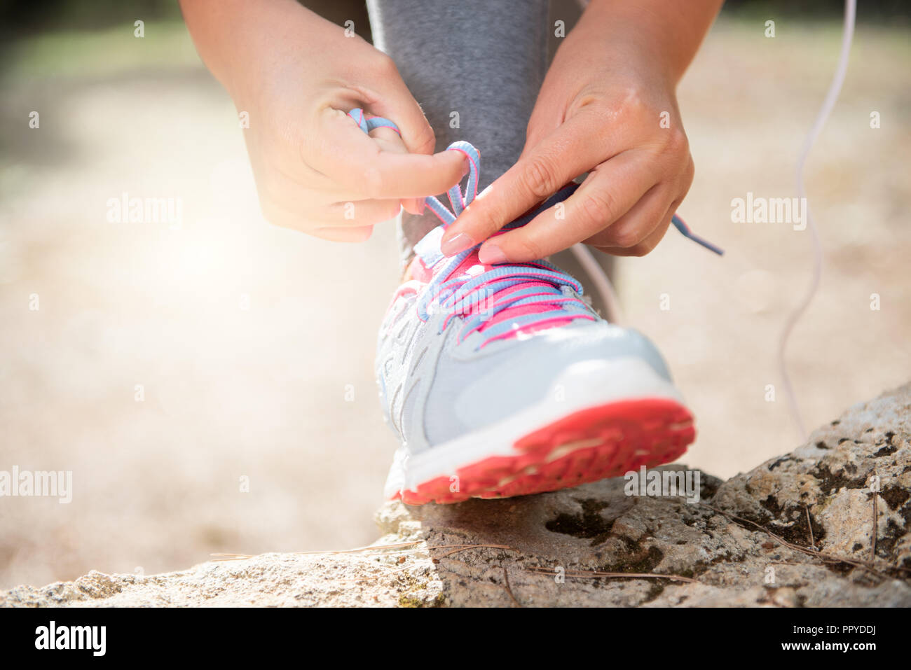 Running shoes. Woman tying shoe laces in the park outdoor Stock Photo - Alamy