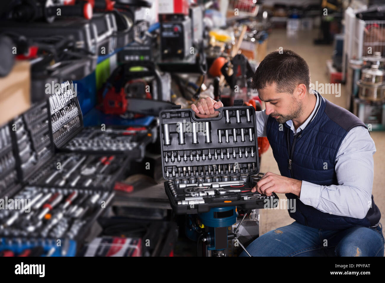 Adult male is standing with new box for tools in store Stock Photo - Alamy