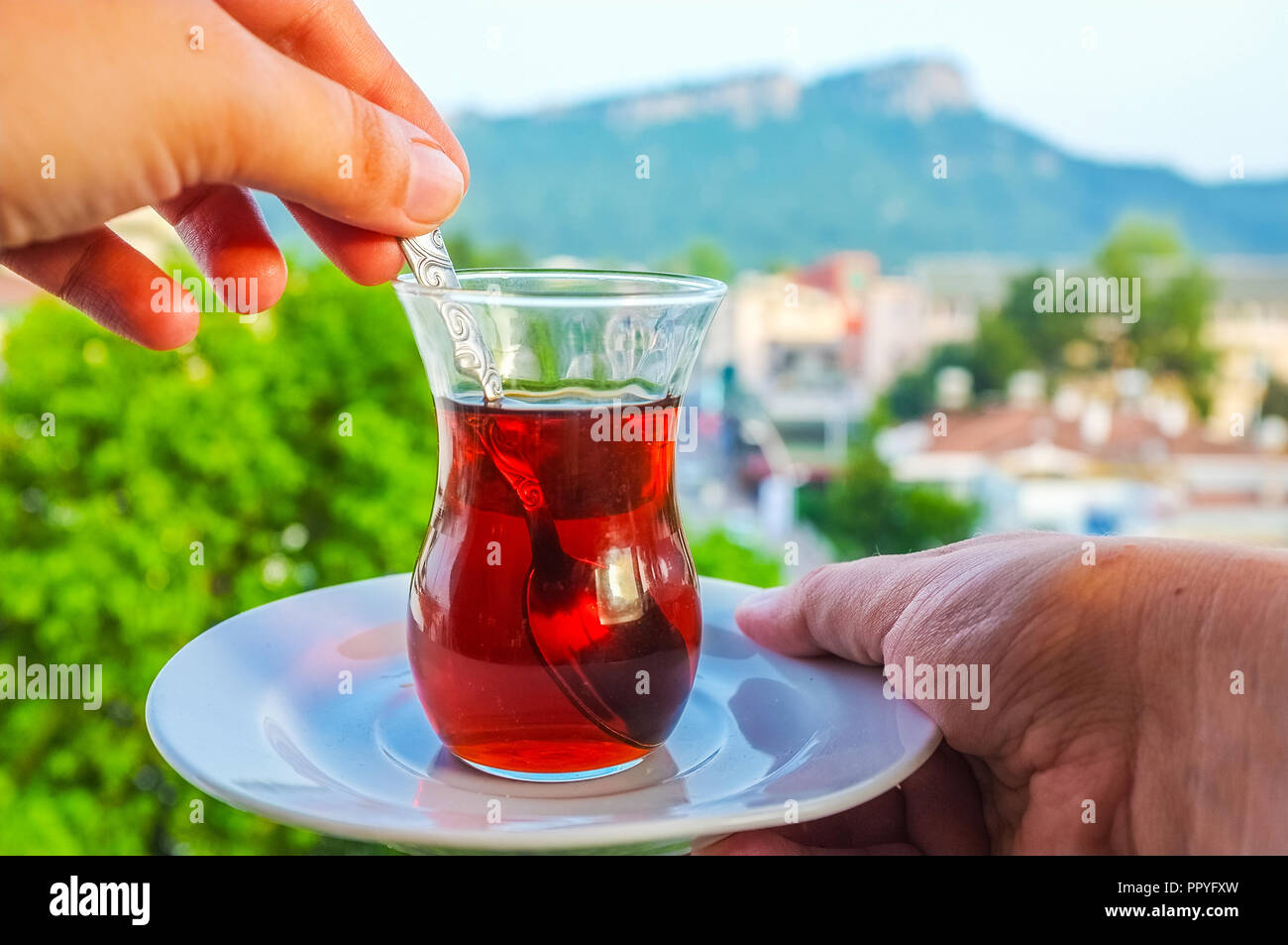 Enjoy a glass of hot black Turkish tea on summer terrace with a view on ...