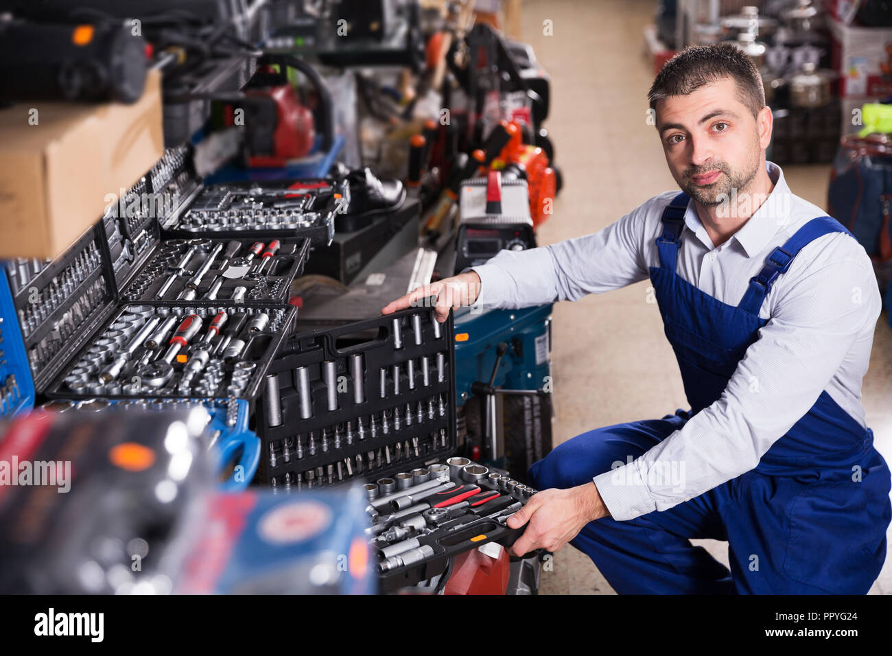 young male is standing with new box for tools in store Stock Photo - Alamy
