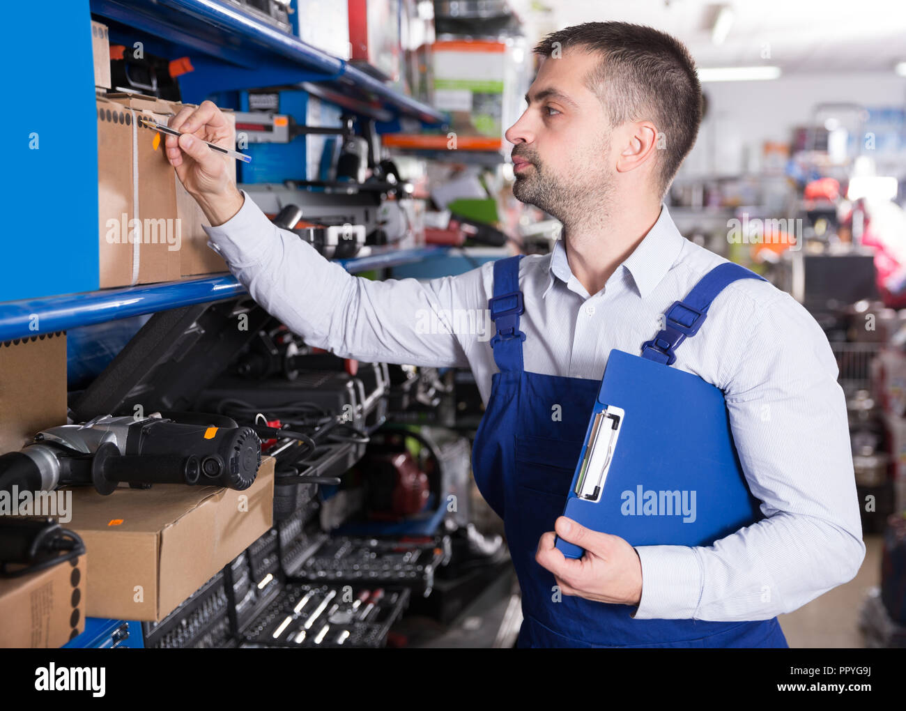 Portrait of worker who is making rediscount in the tools store Stock ...