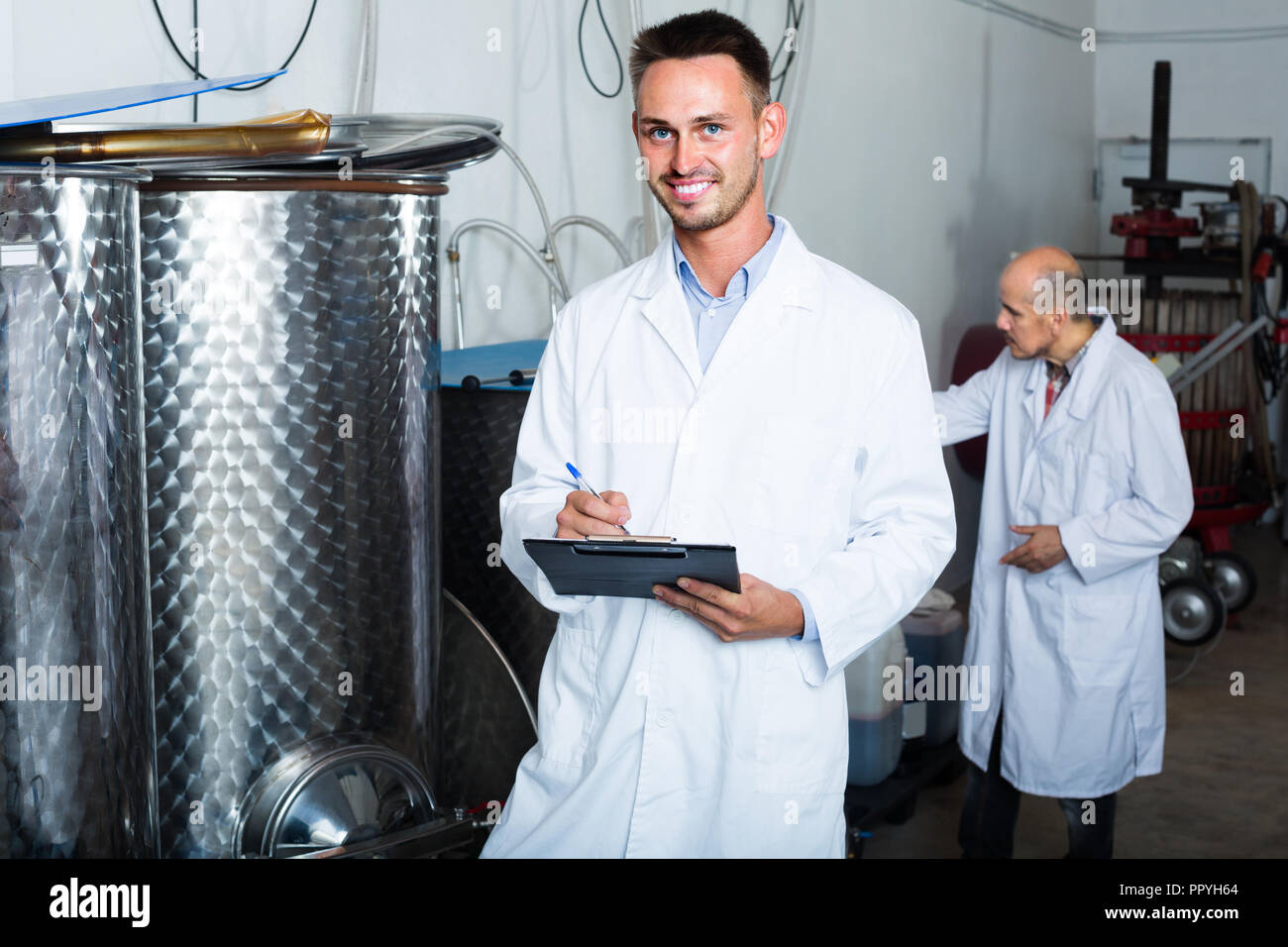 portrait of cheerful expert wearing white coat man standing with ...