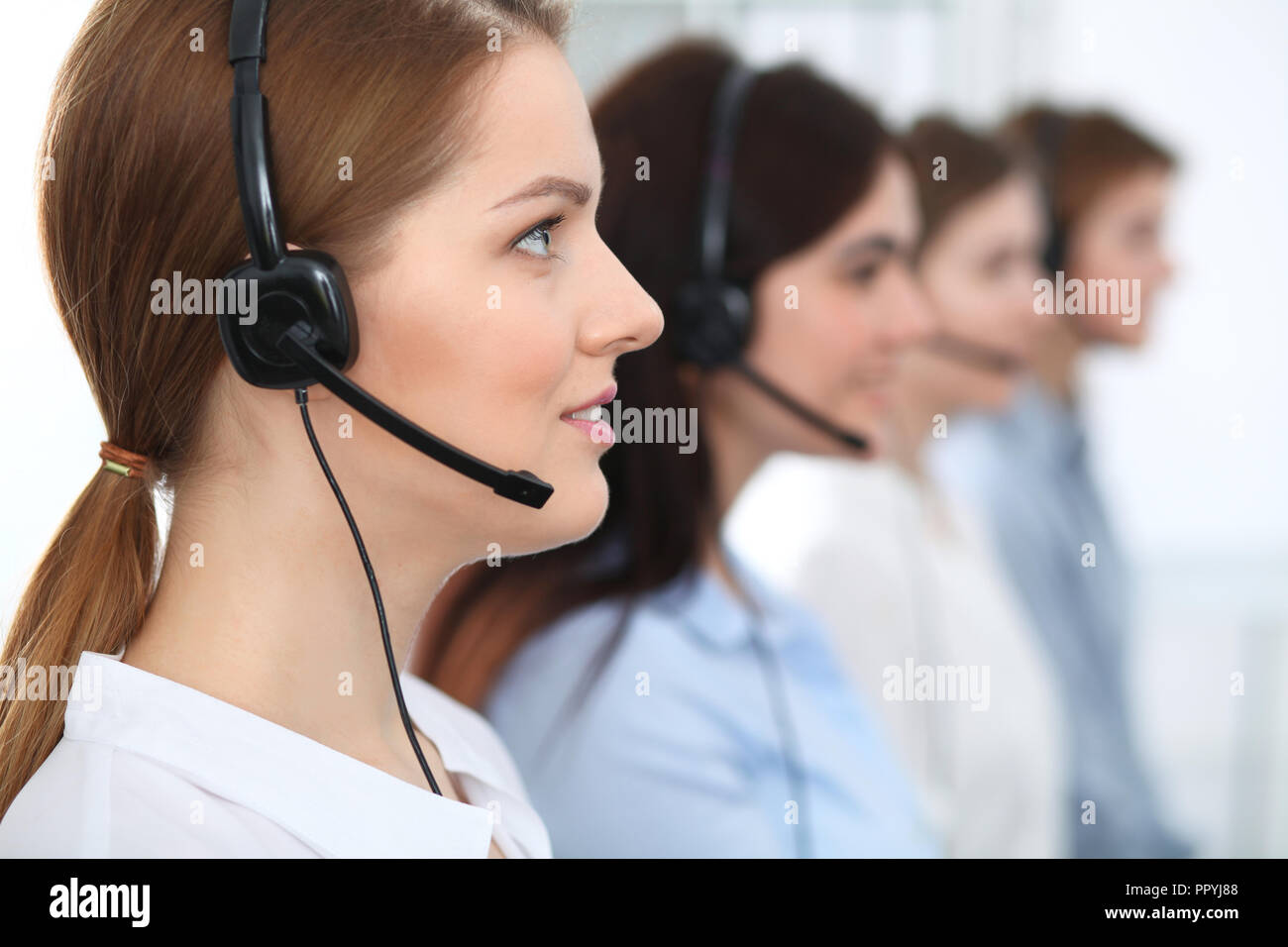 Call center. Beautiful cheerful smiling operator consulting clients ...