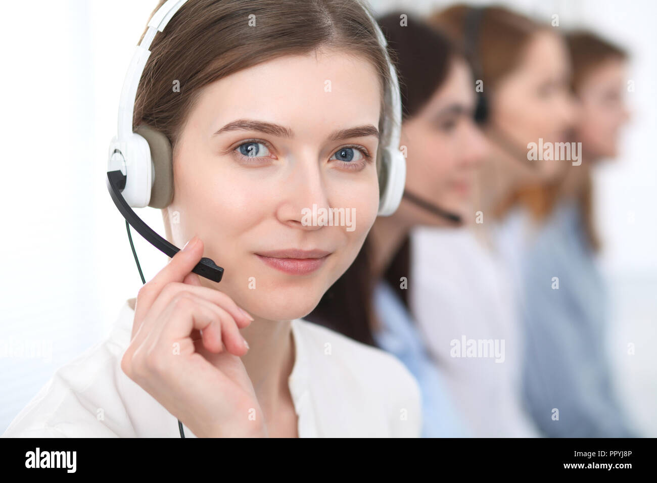 Call center. Beautiful cheerful smiling operator consulting clients with headset. Business ...