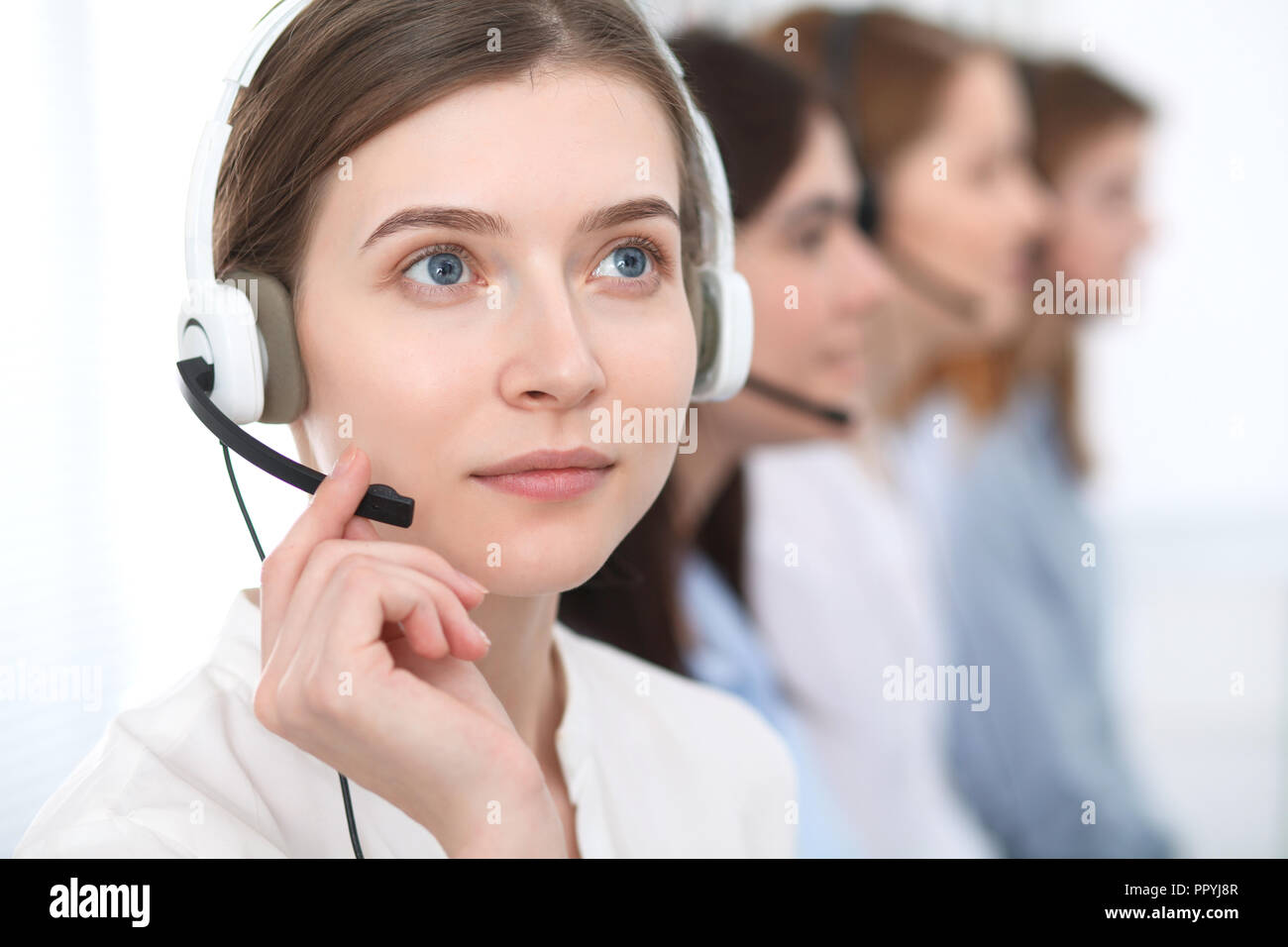 Call center. Beautiful cheerful smiling operator consulting clients ...