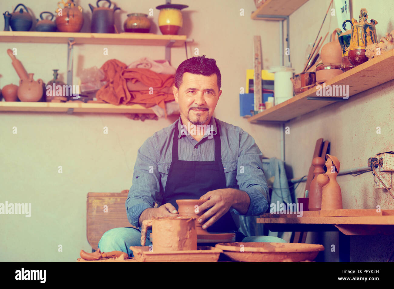 Positive senior man making pot using pottery wheel in studio Stock ...