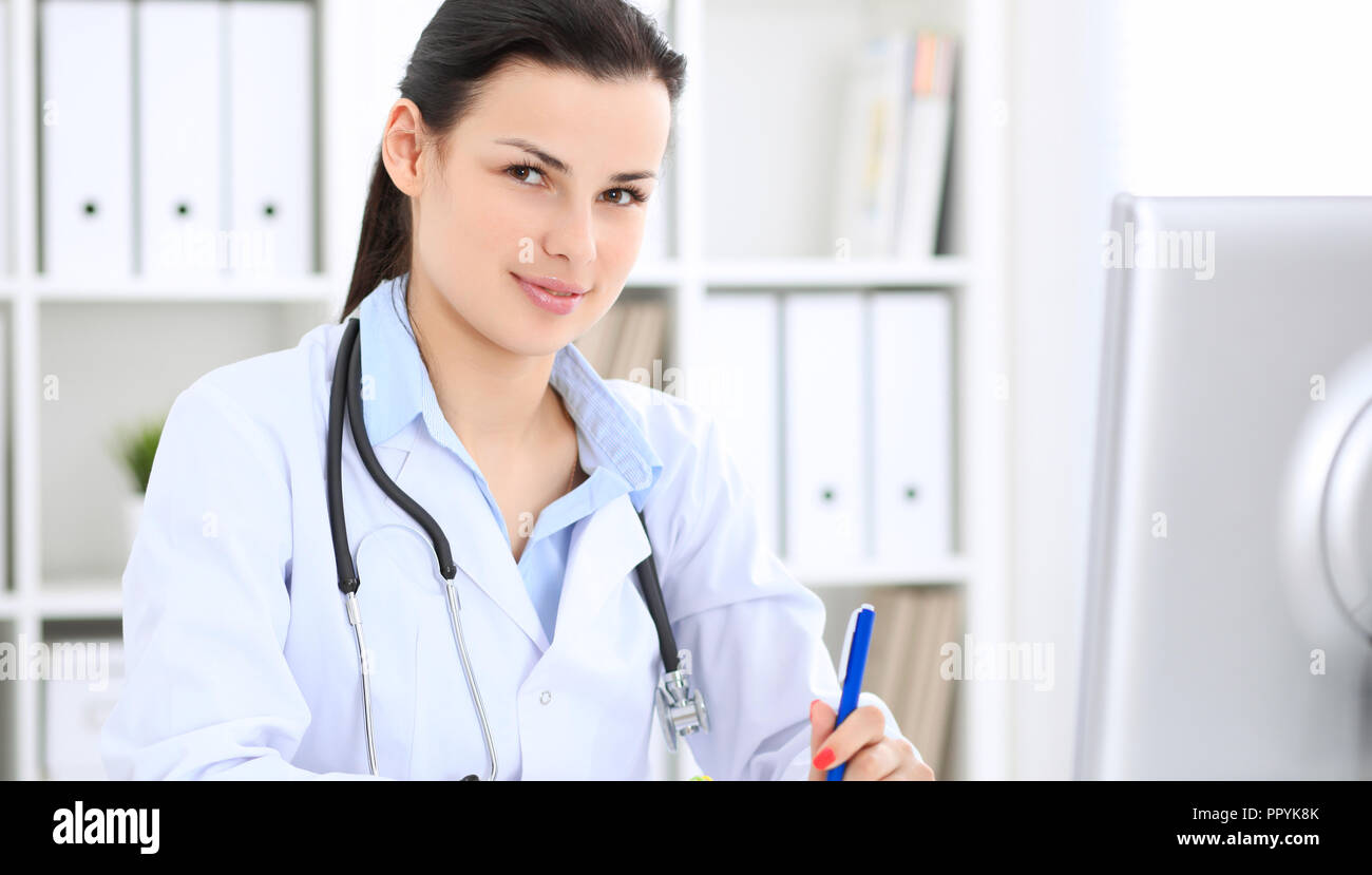 Young brunette female doctor at working place in hospital. Health care ...
