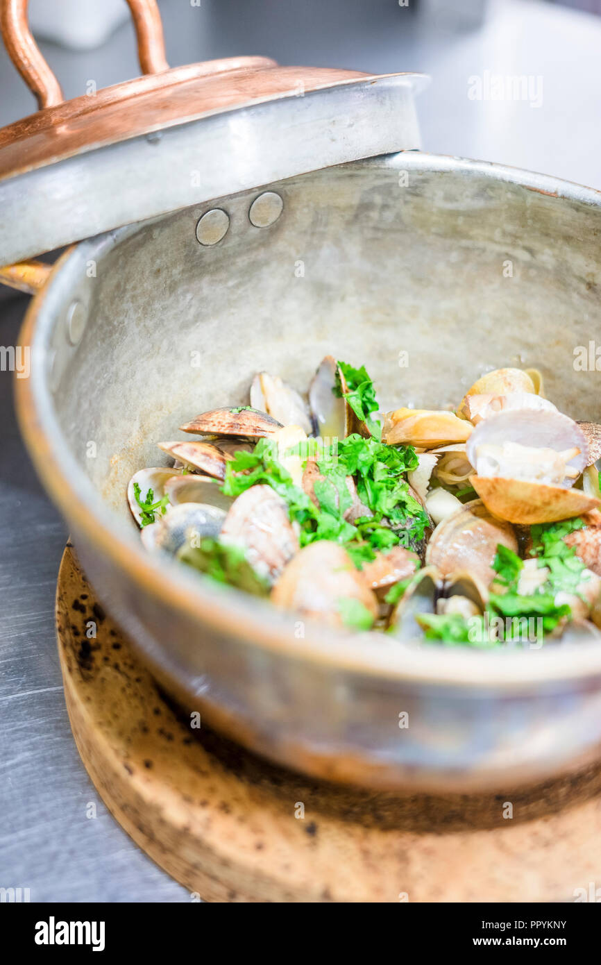 Clams with garlic and coriander in a copper, bronze pot with lid Stock ...