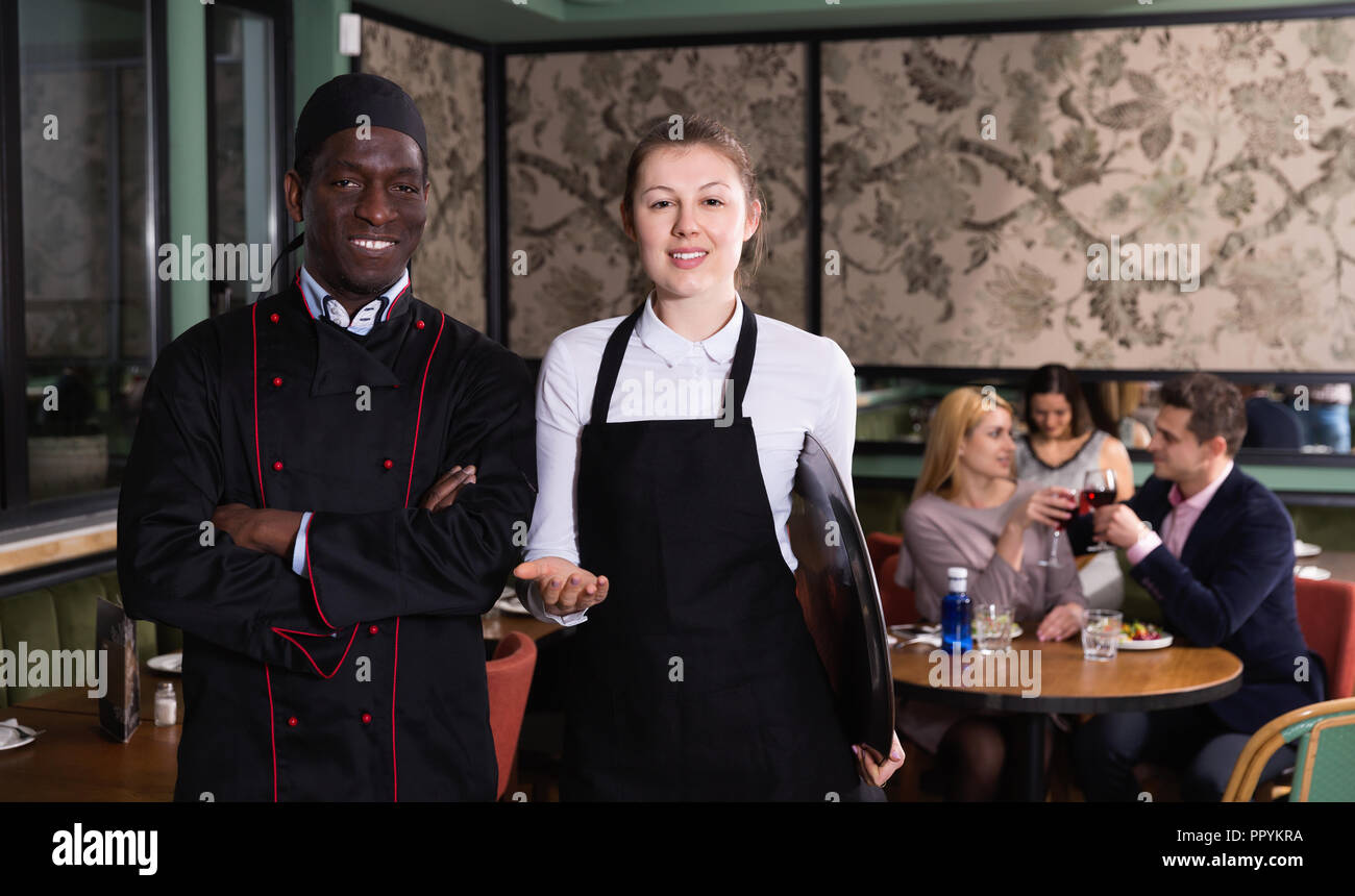 Polite happy cheerful positive smiling waitress standing in restaurant ...