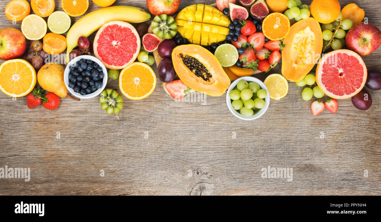 Top view of rainbow colored fruits, strawberries blueberries, mango ...