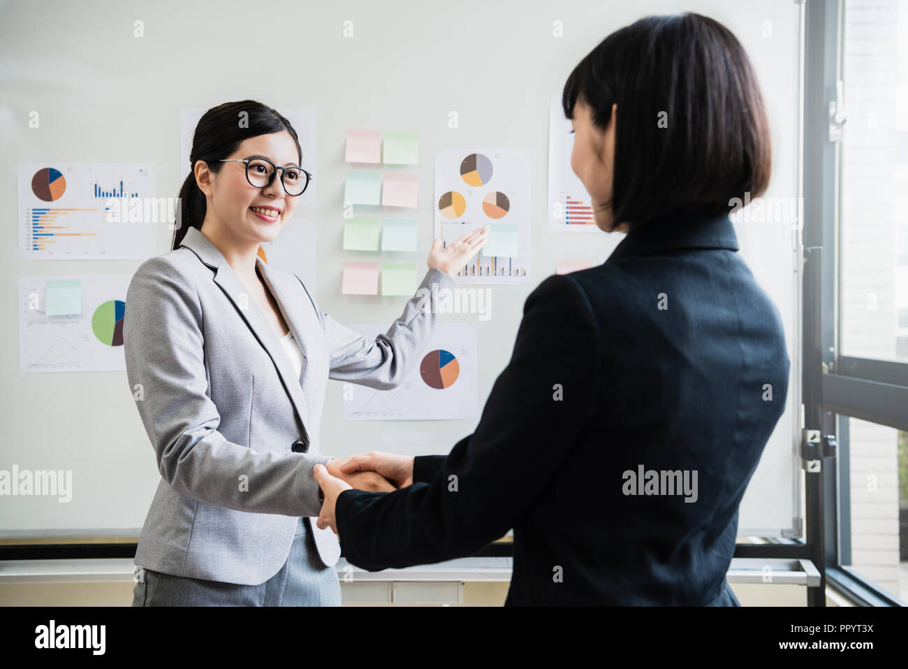 Businesswomen shaking hands in front hi-res stock photography and ...