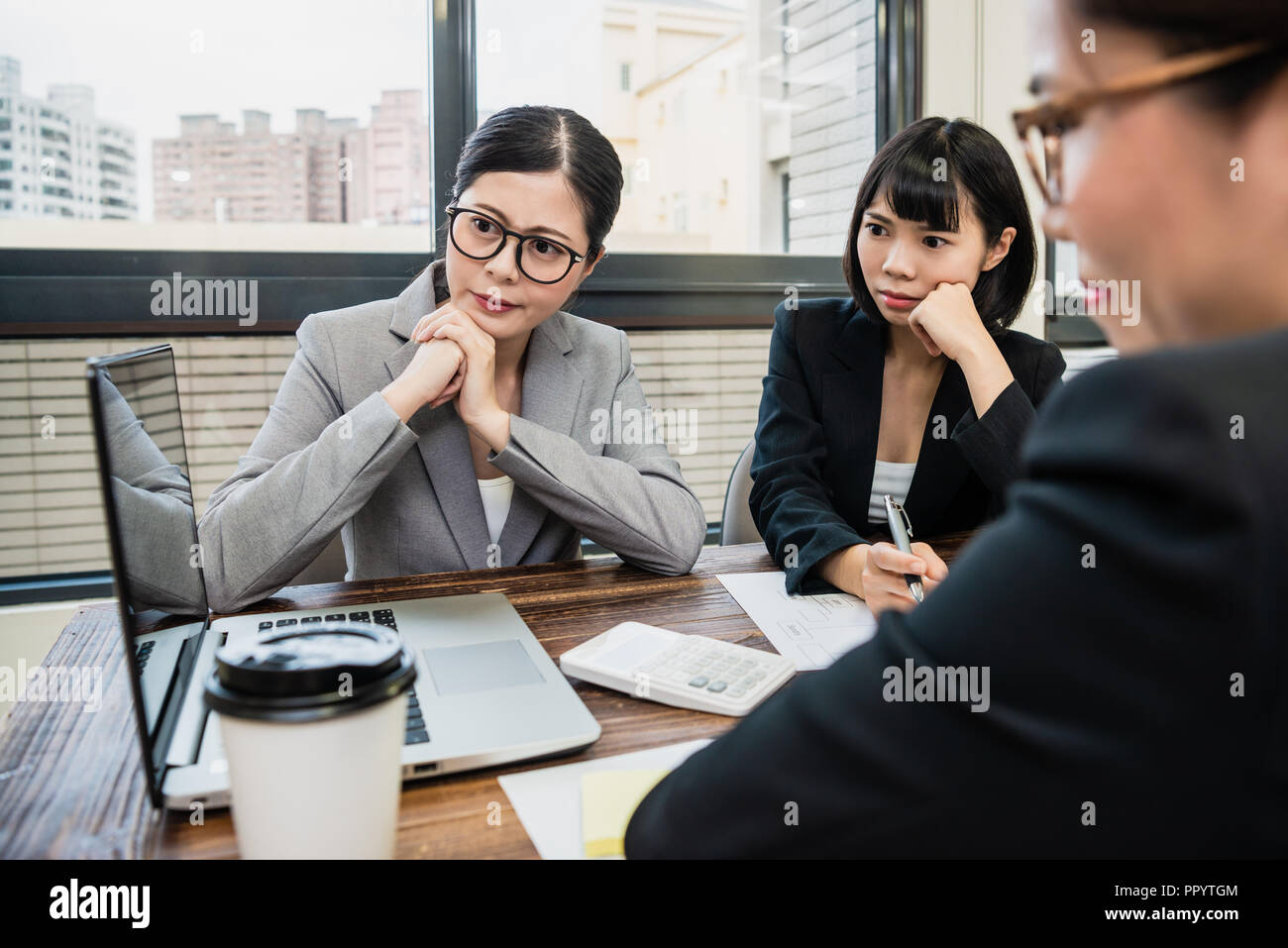 group of businesswomen concentrated staring at the laptop and thinking ...