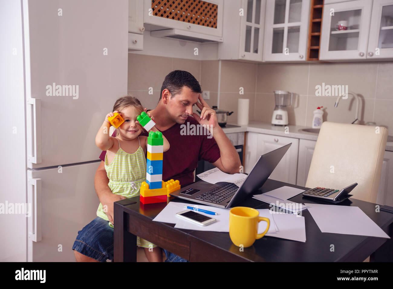 Family - busy father working with computer while looking after his ...