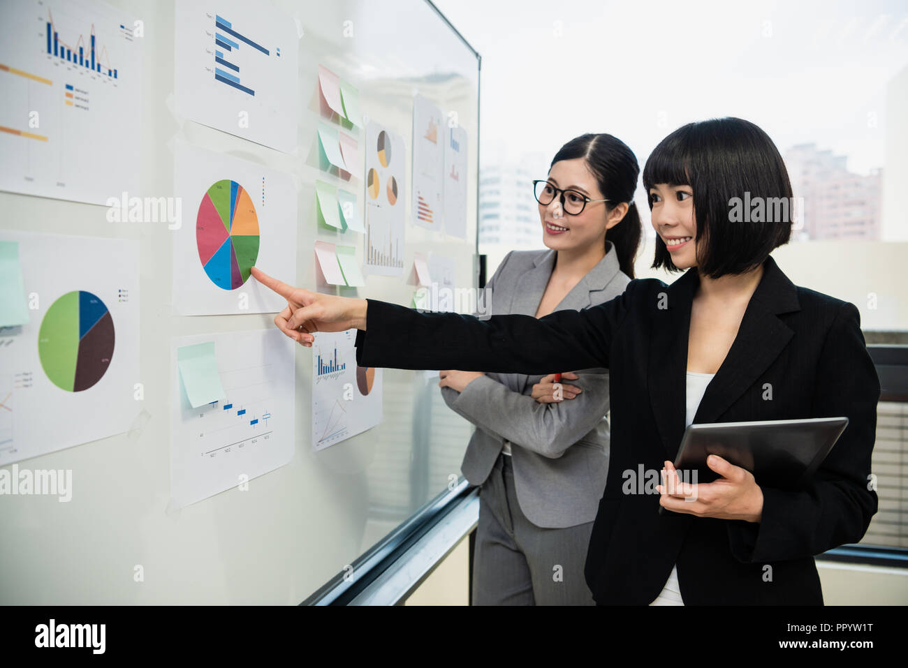 the businesswoman is explaining the chart to her manager in front of ...