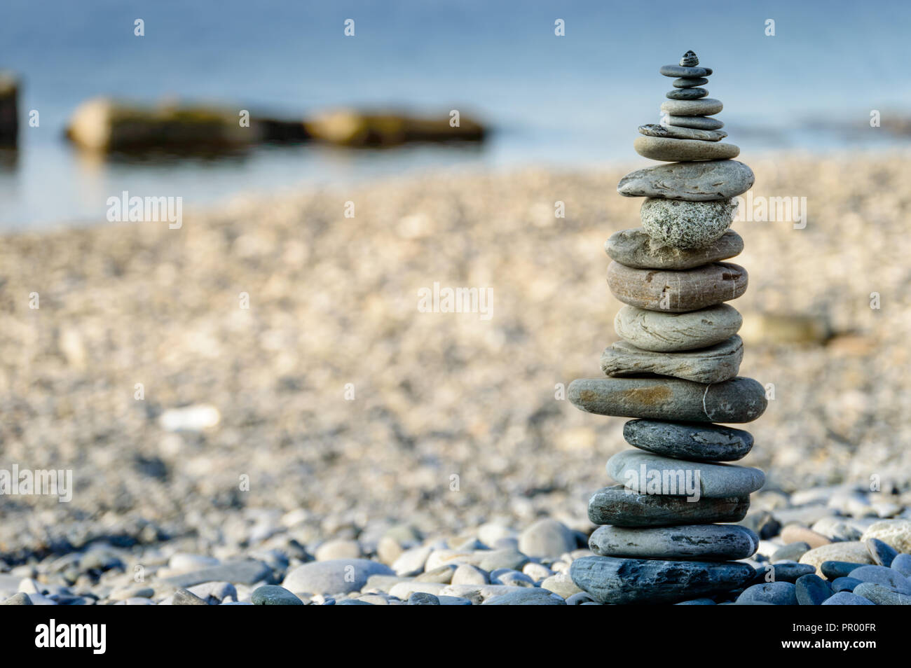 Pyramid of sea stones on pebbles of the sea shore. The concept of ...