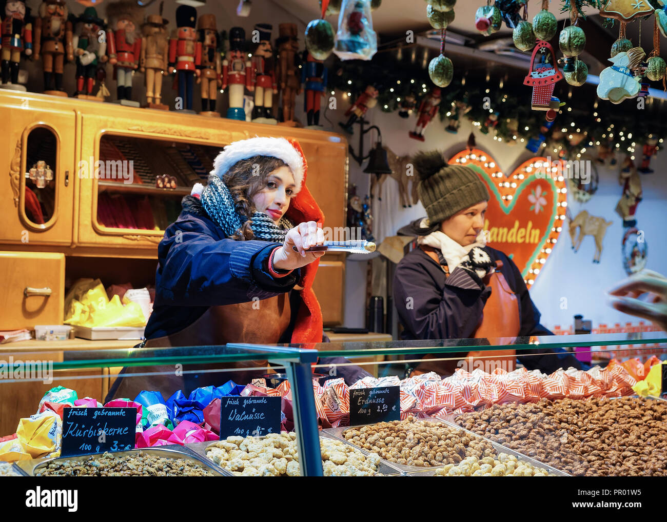 Berlin, Germany - December 10, 2017: Girls selling sweet nuts at Night ...
