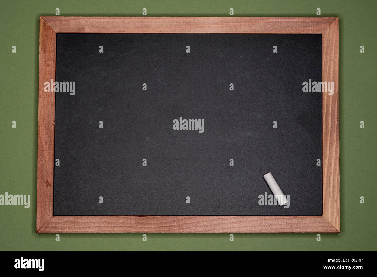 Empty chalk board with wooden frame on green background, blank copy ...