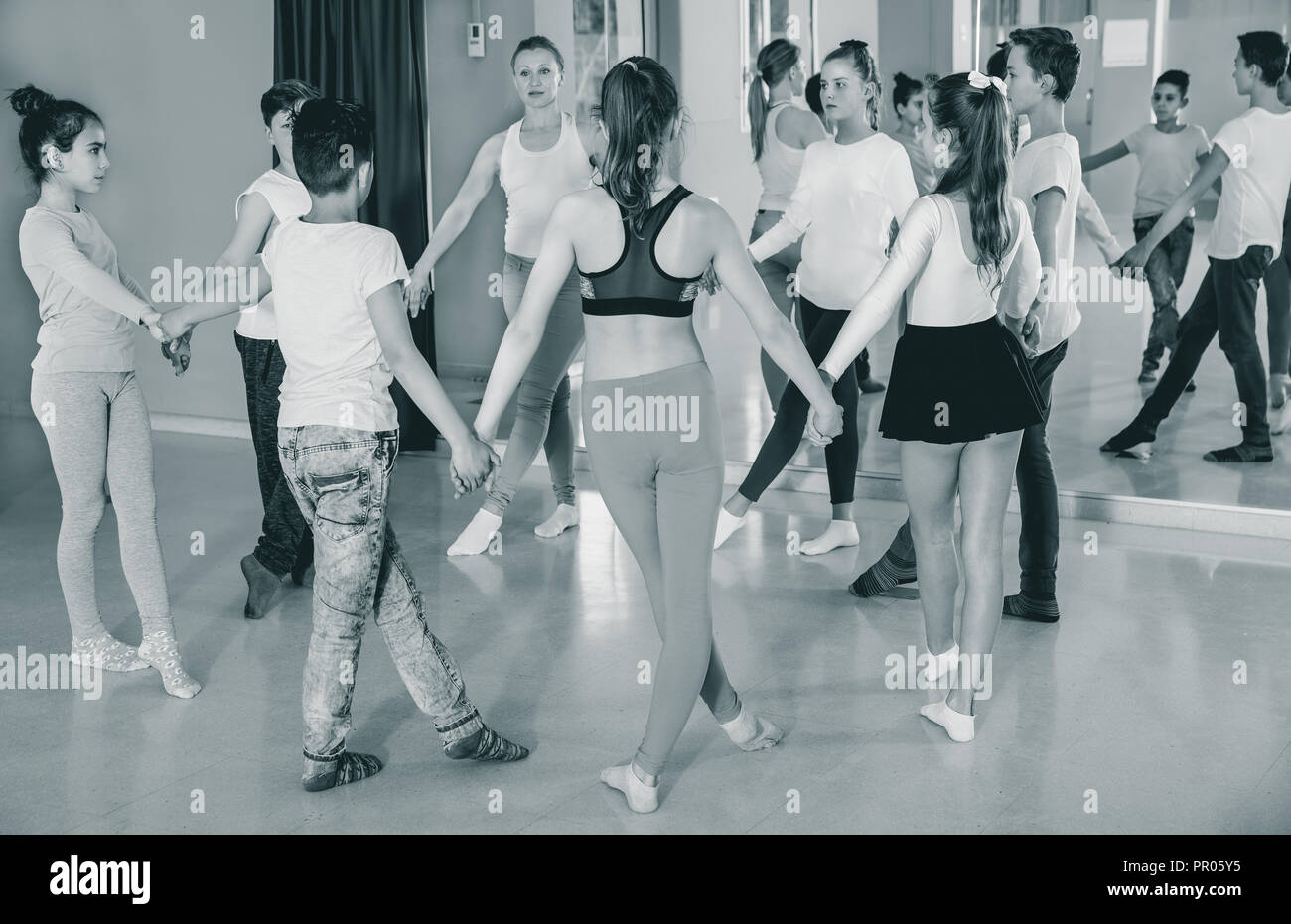 Group of children with their teacher holding hands and dancing in ...