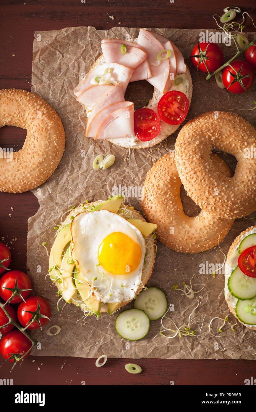 variety of sandwiches on bagels: egg, avocado, ham, tomato, soft cheese ...