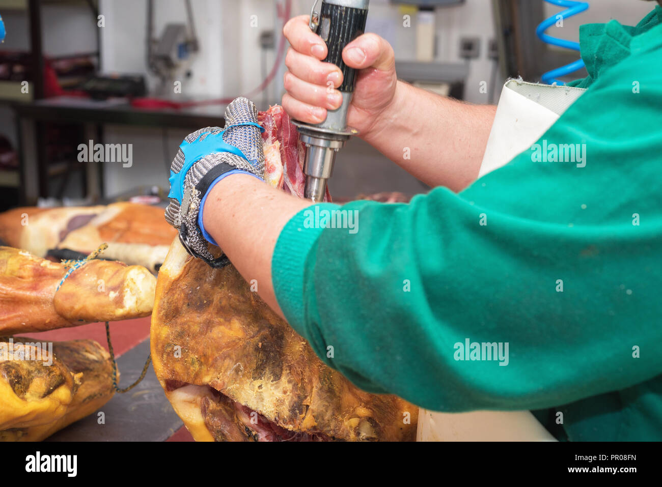 Close up of worker hands in the industrial process of cutting iberian ...