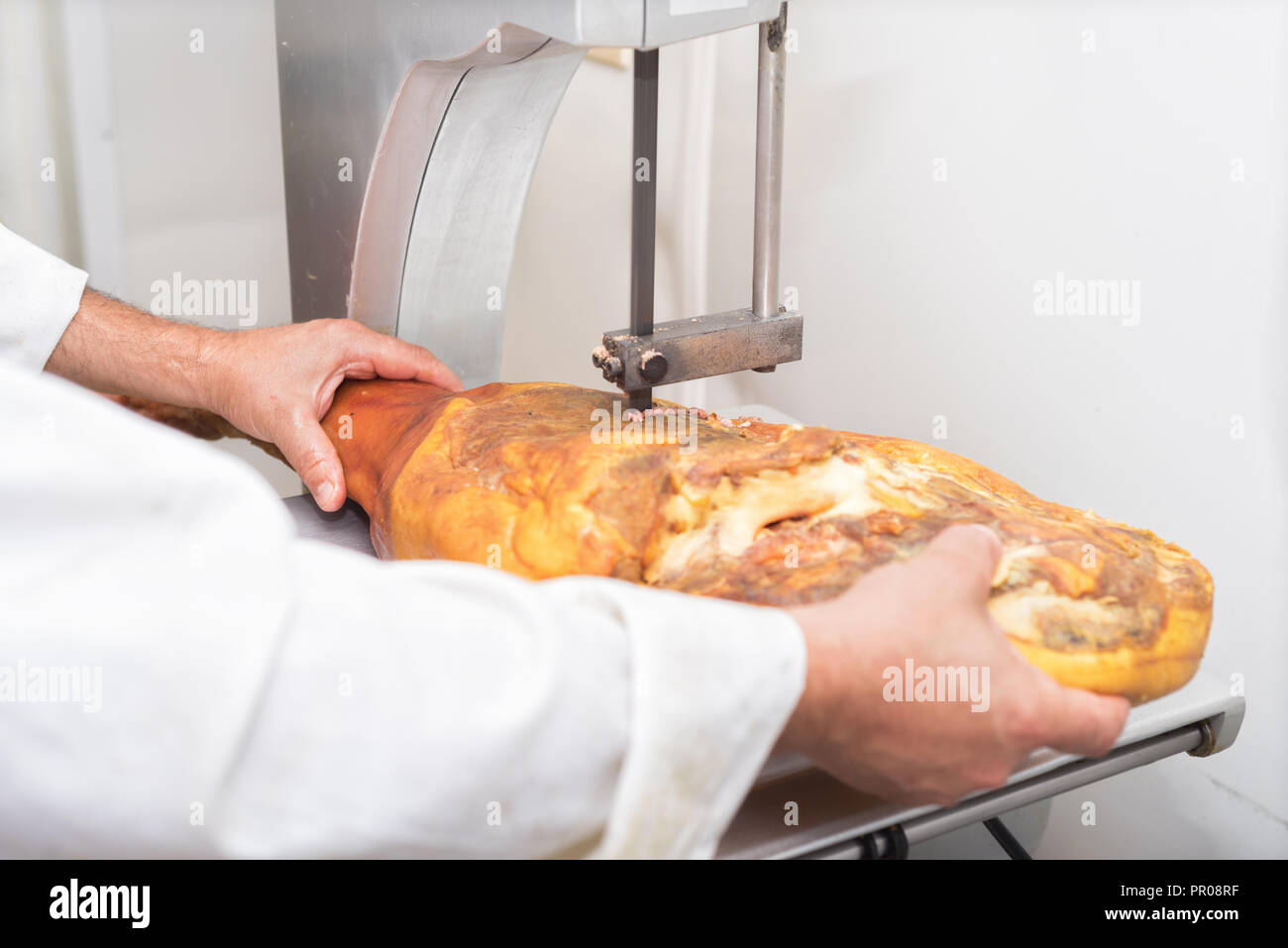 Close up of worker hands in the industrial process of cutting iberian ...