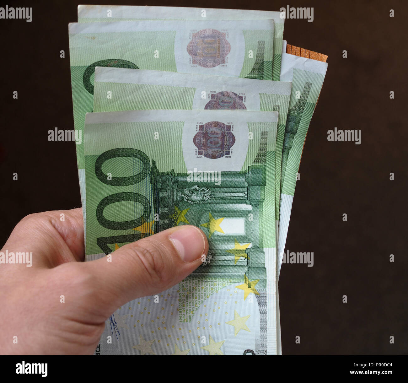 Hand holding and giving Euro banknotes money (EUR), currency of ...