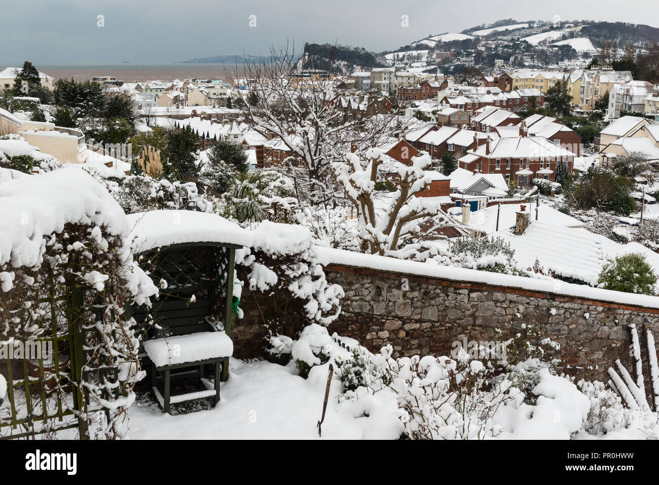 View out to sea looking over the town with rooftops covered in snow in ...