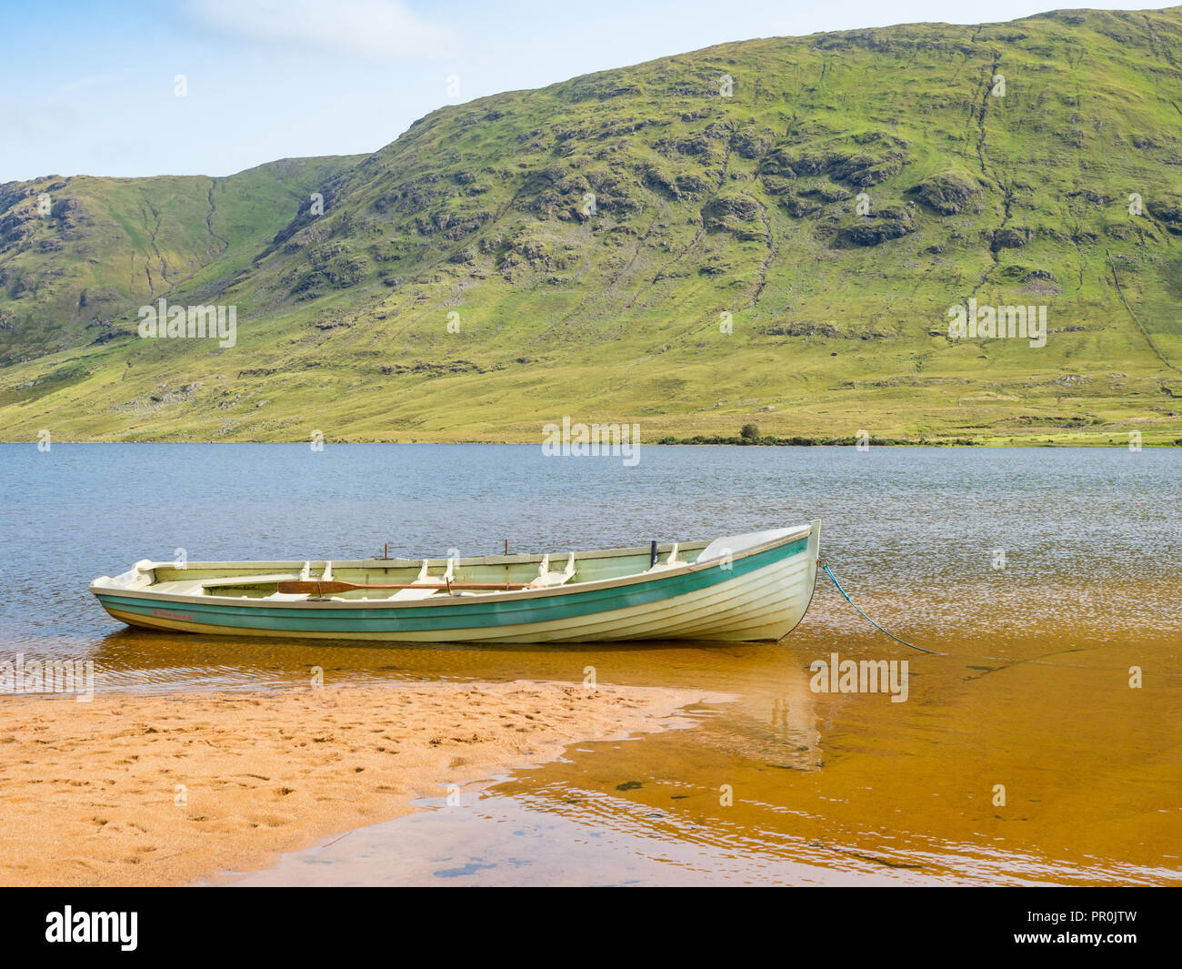 A boat on the beach at scenic Lake Nafooey in the Connemara region of ...