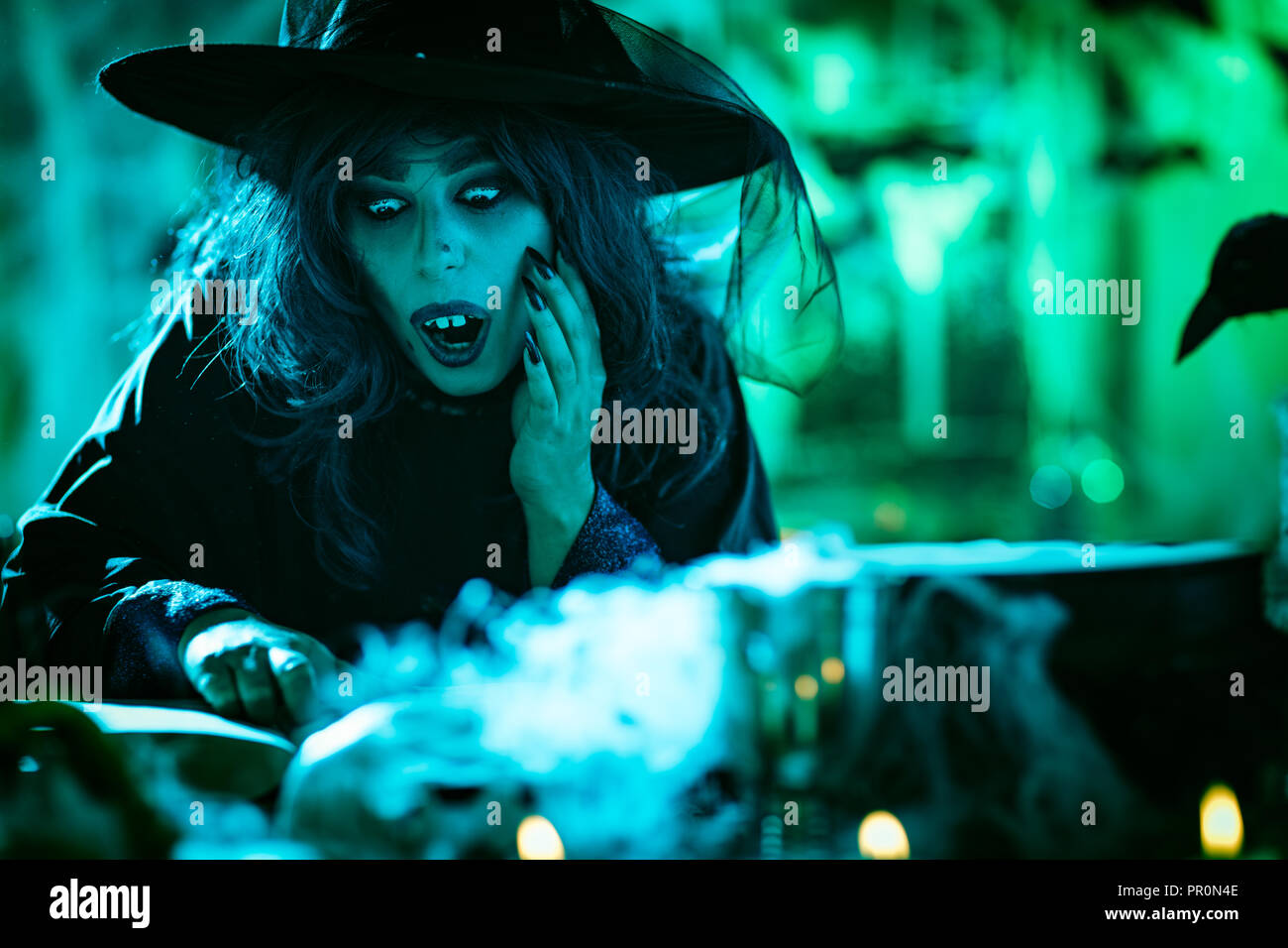 Witch with awfully face in creepy smoky green surroundings full of ...