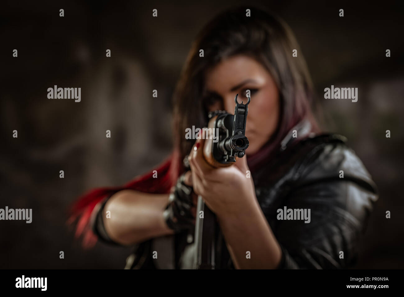 Attractive girl standing in the attitude of aiming and looking through ...