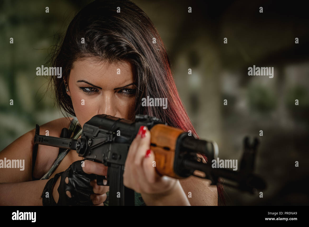 Attractive girl standing in the attitude of aiming and looking through ...