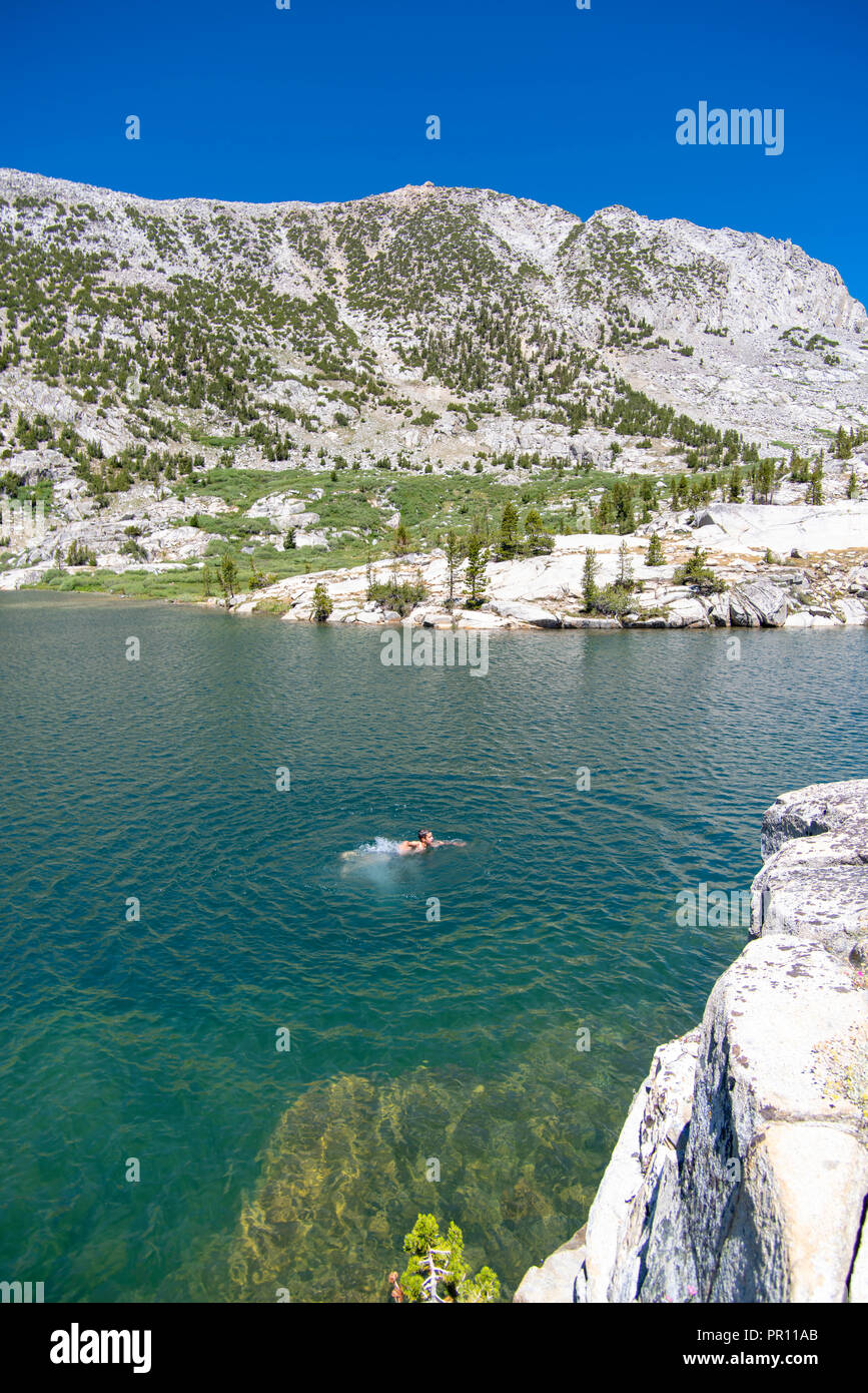 A teenage boy swims at Sallie Keyes Lakes along the John Muir Trail ...