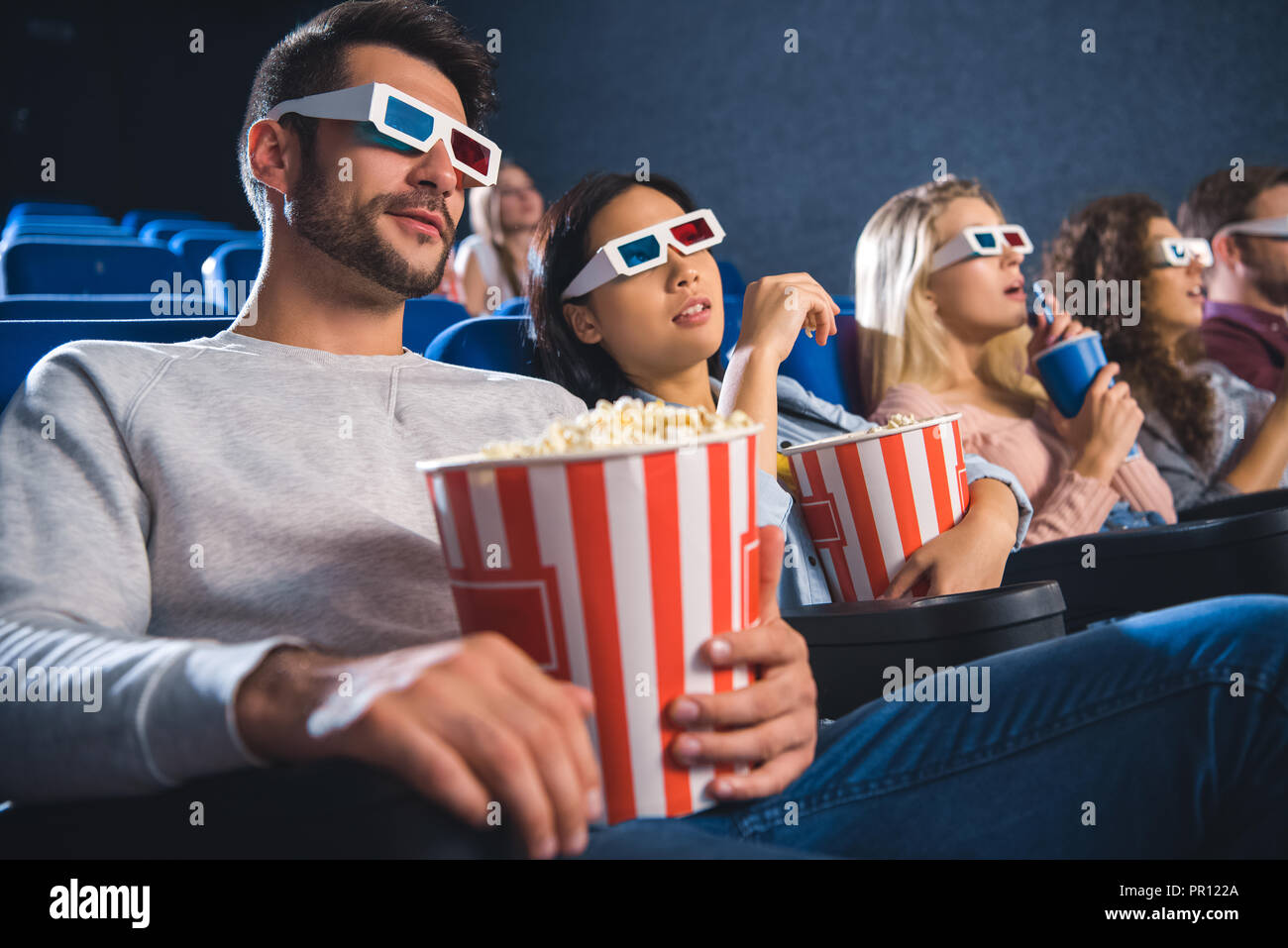 multiethnic friends in 3d glasses with popcorn watching film together in movie theater Stock ...