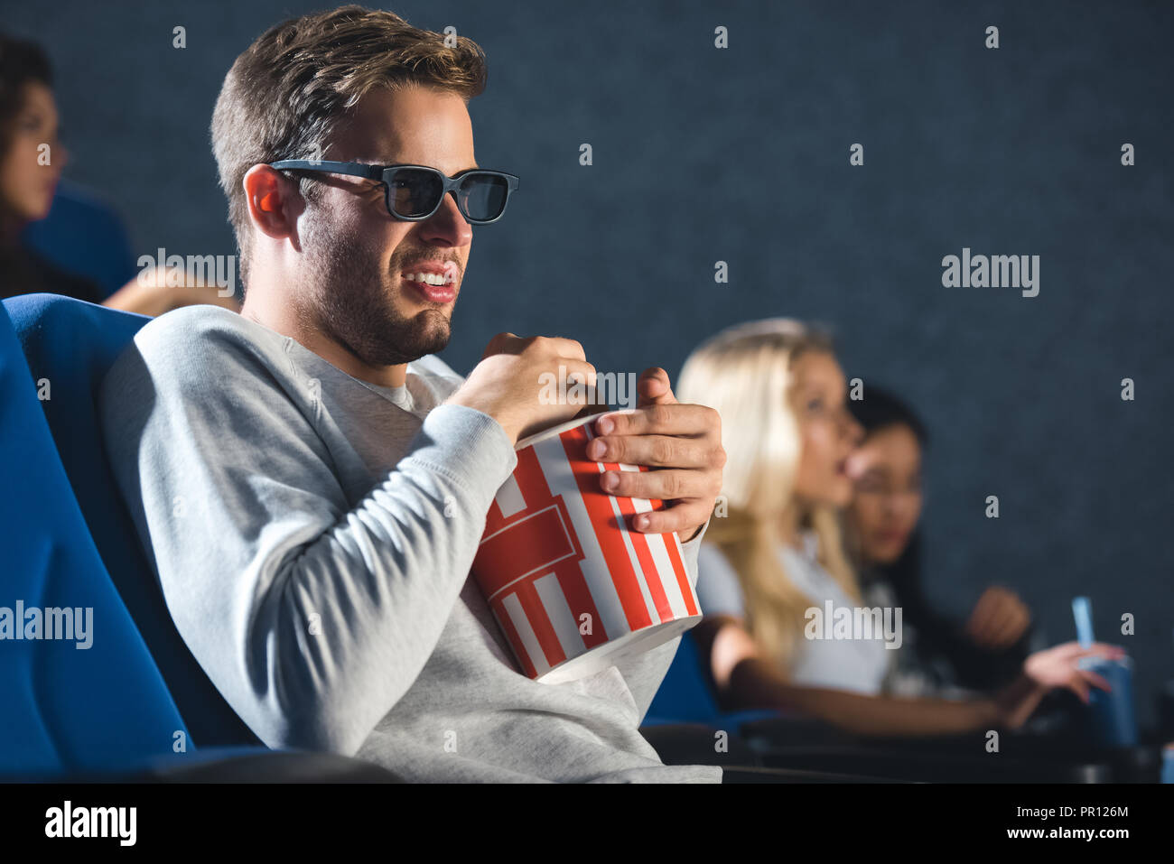 side view of disgusted man in 3d glasses with popcorn watching film in cinema Stock Photo - Alamy