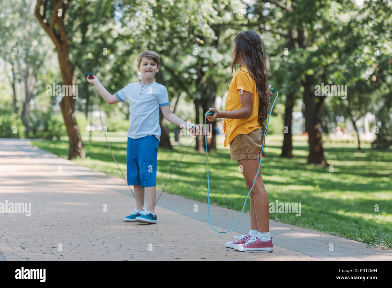 cute happy children playing with skipping ropes in park Stock Photo - Alamy