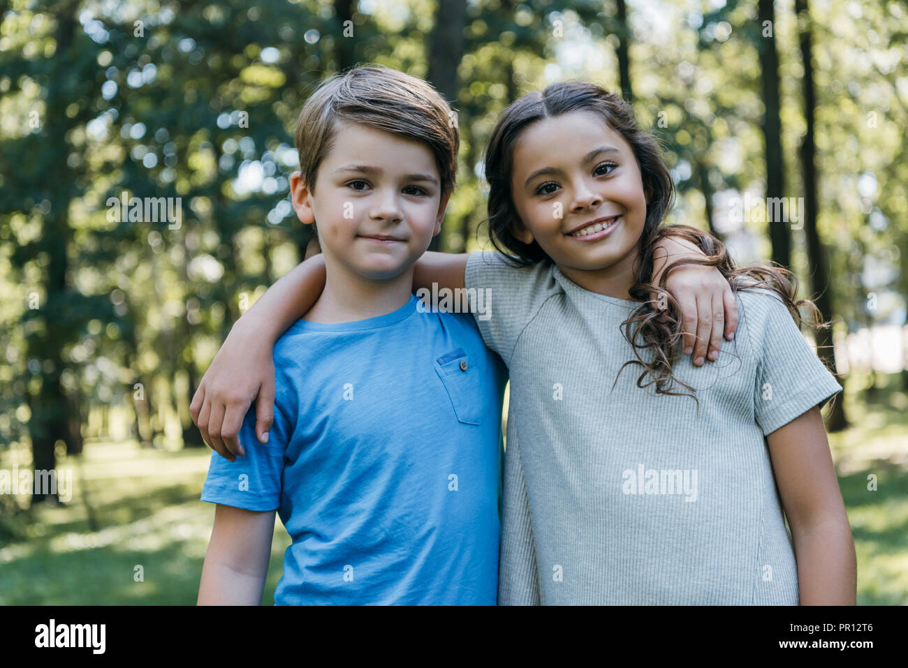 beautiful happy kids hugging and smiling at camera in park Stock Photo ...