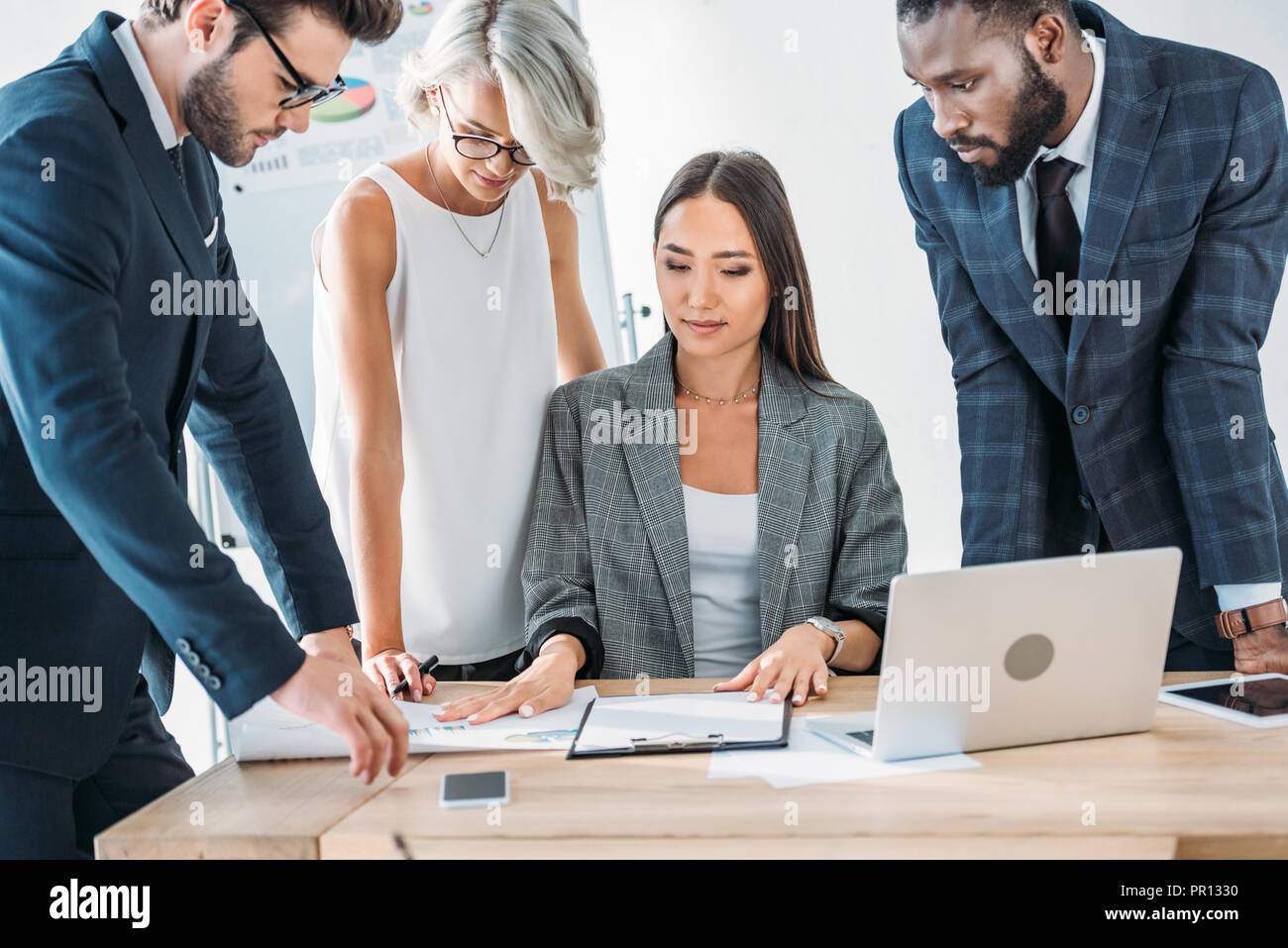 young multicultural businesspeople standing around team leader and ...