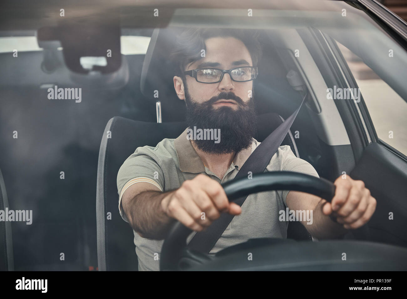 A Young attractive man driving a vehicle, looking at scenery, seen ...
