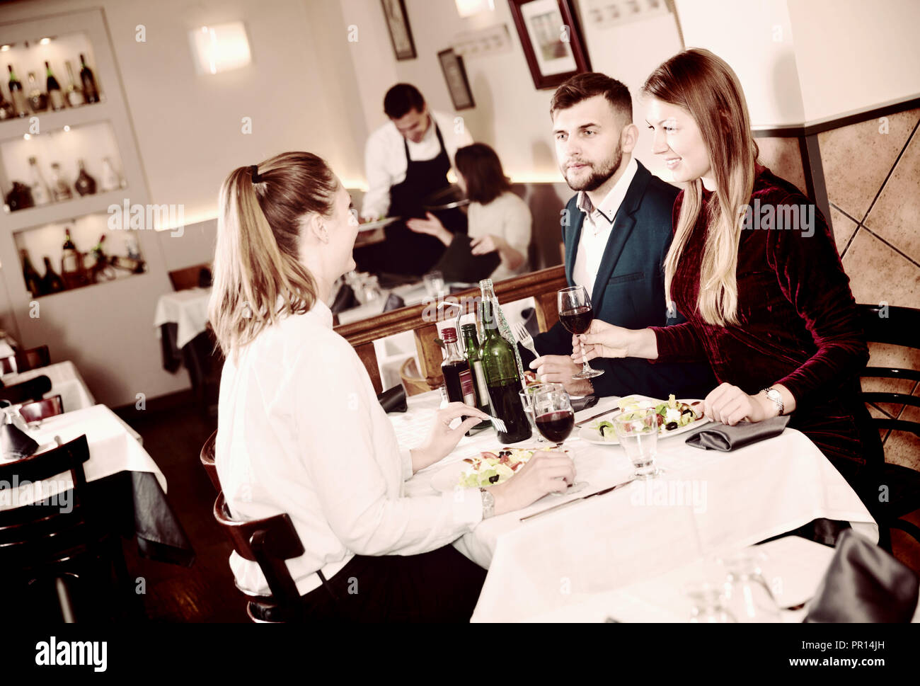 Glad cheerful positive smiling friendly meeting over dinner with wine ...