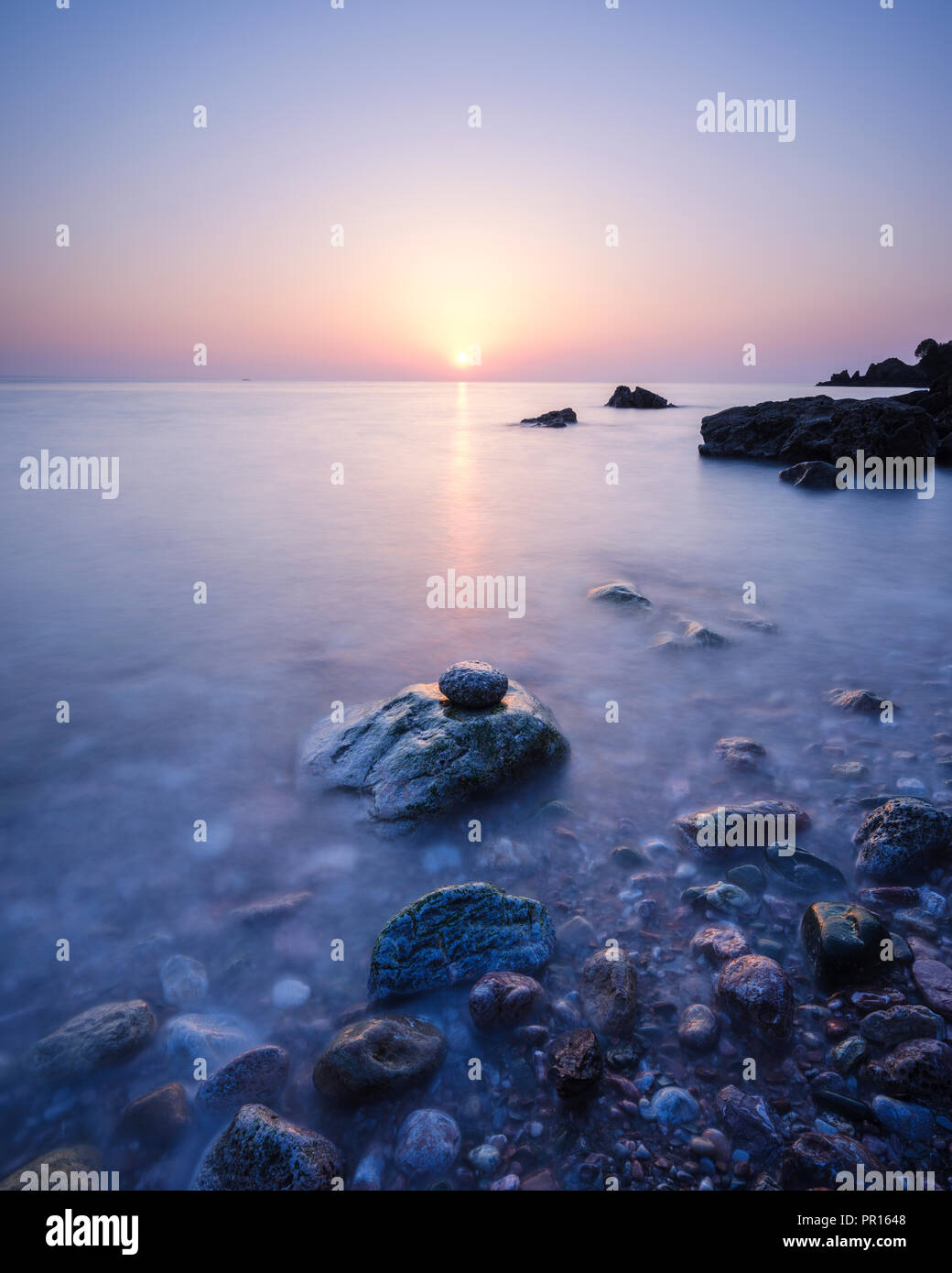 A colourful spring sunrise over Torbay with warm light glinting off the ...